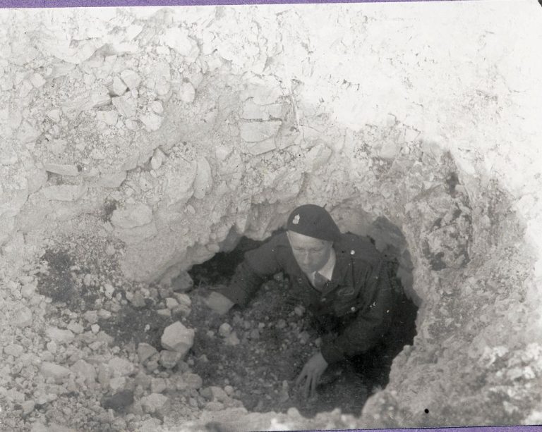 A member of the A.R.P. crawling out of a bomb crater. – WW2 in Brighton ...